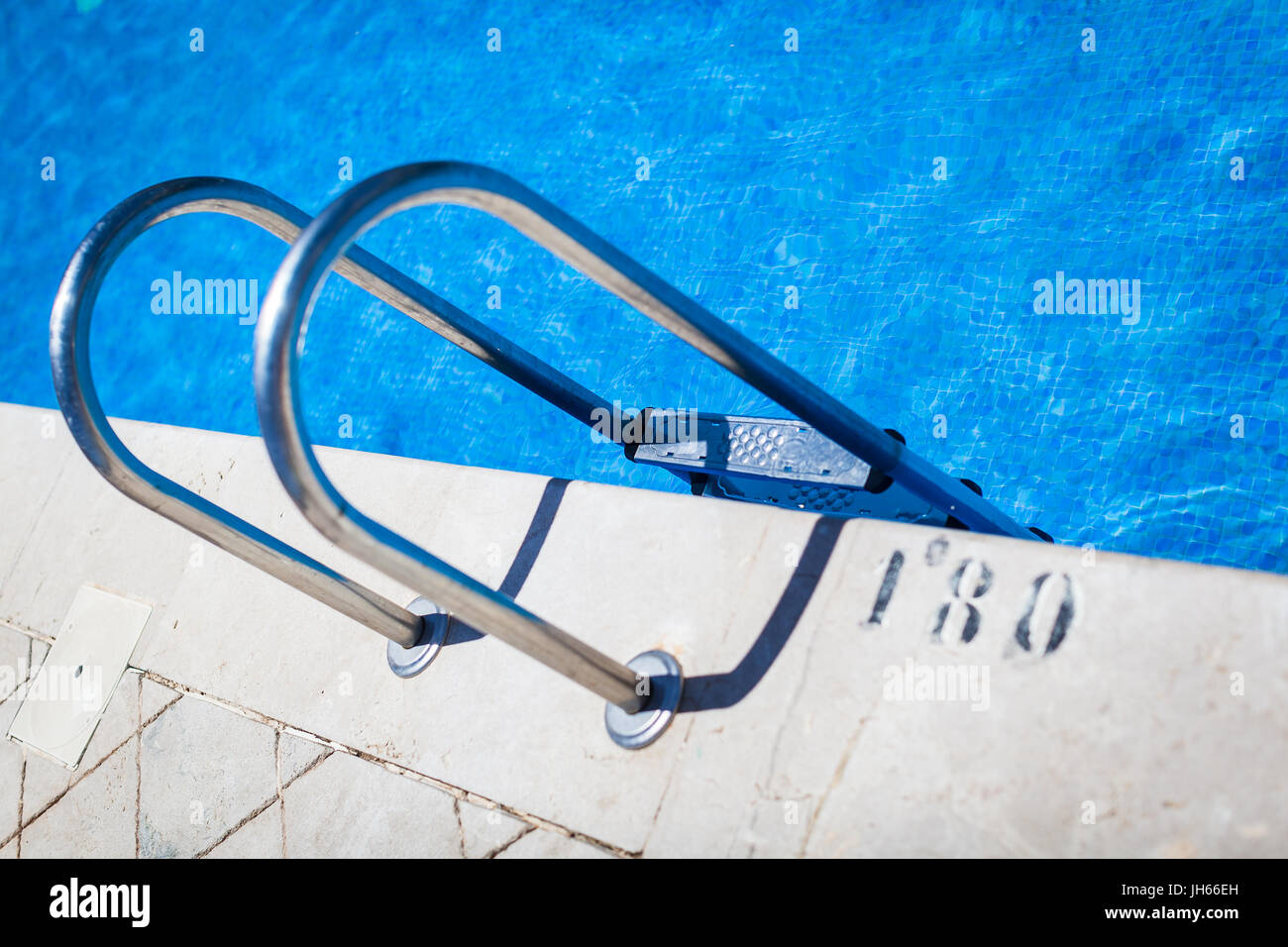 Ladders going into an outdoor swimming pool Stock Photo - Alamy