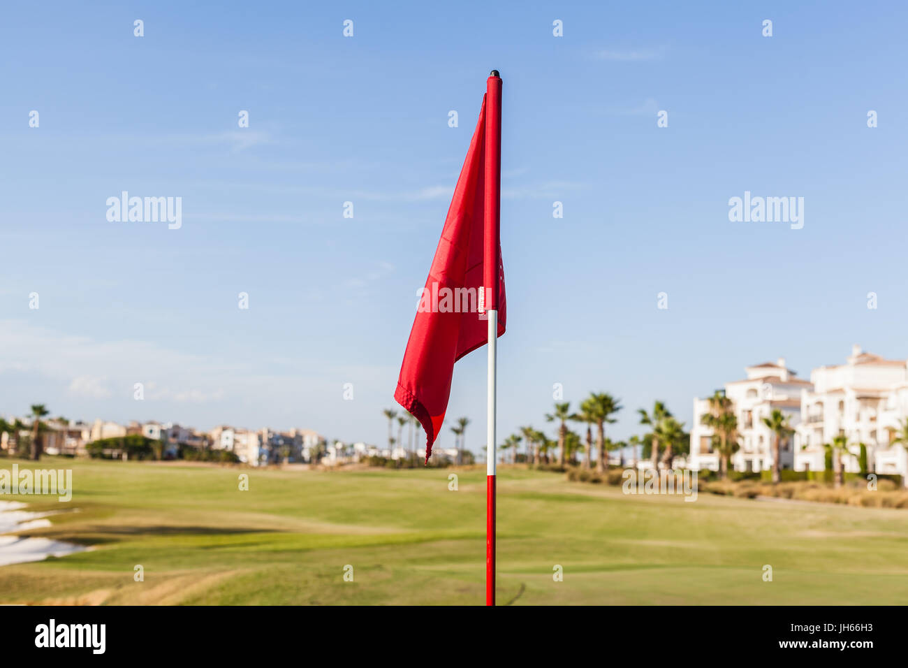 Red golf flag on in the hole of a golf course Stock Photo - Alamy