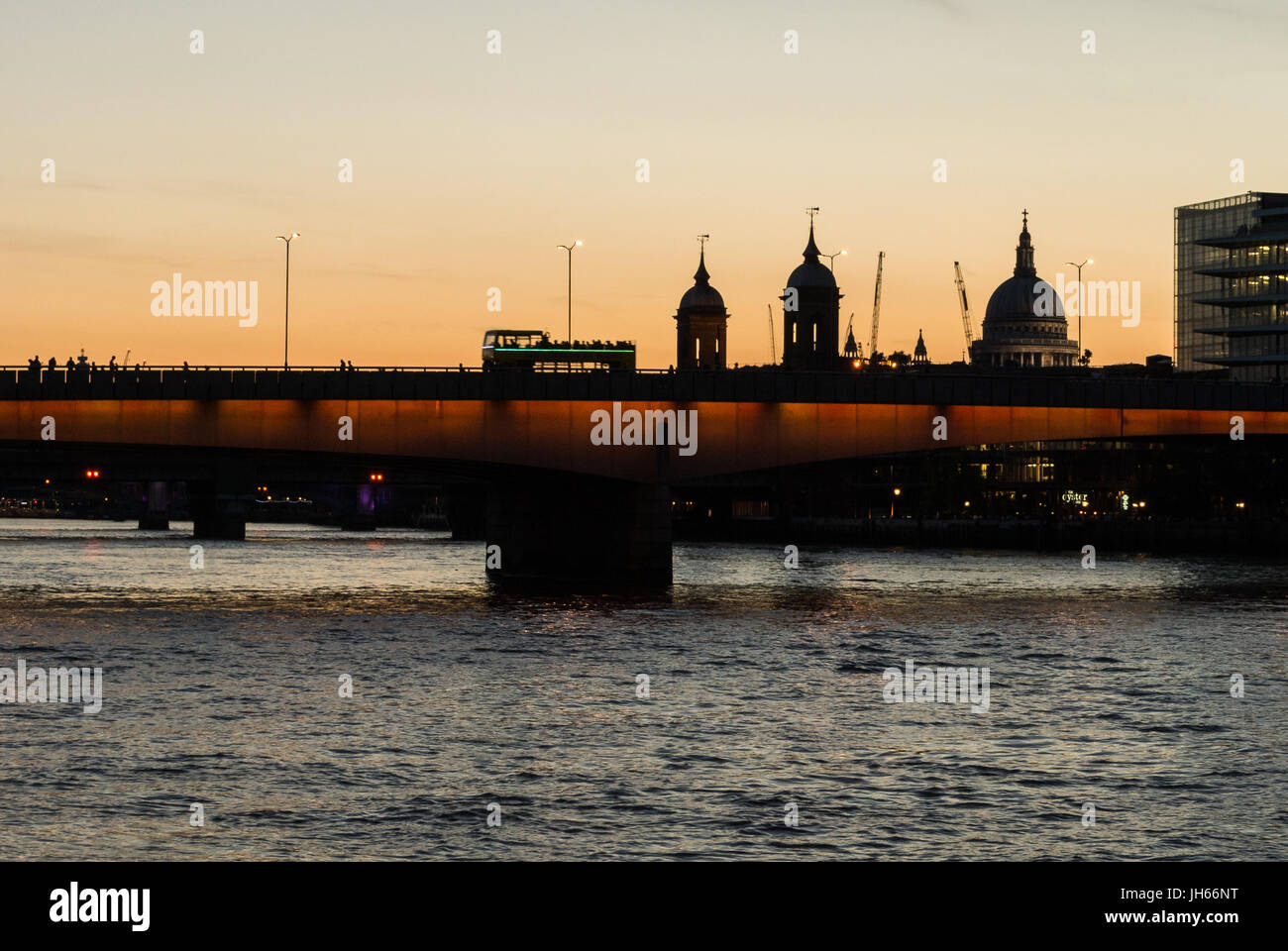 A night bus passes over London Bridge at sunset Stock Photo - Alamy