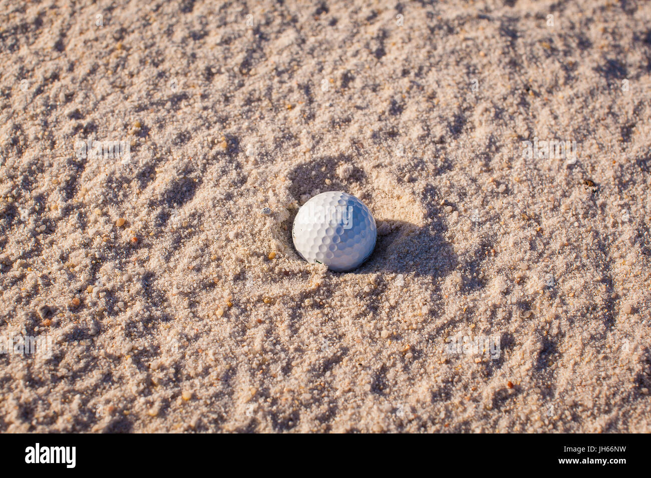 Golf ball in the sand of a bunker on golf course on a sunny day Stock ...