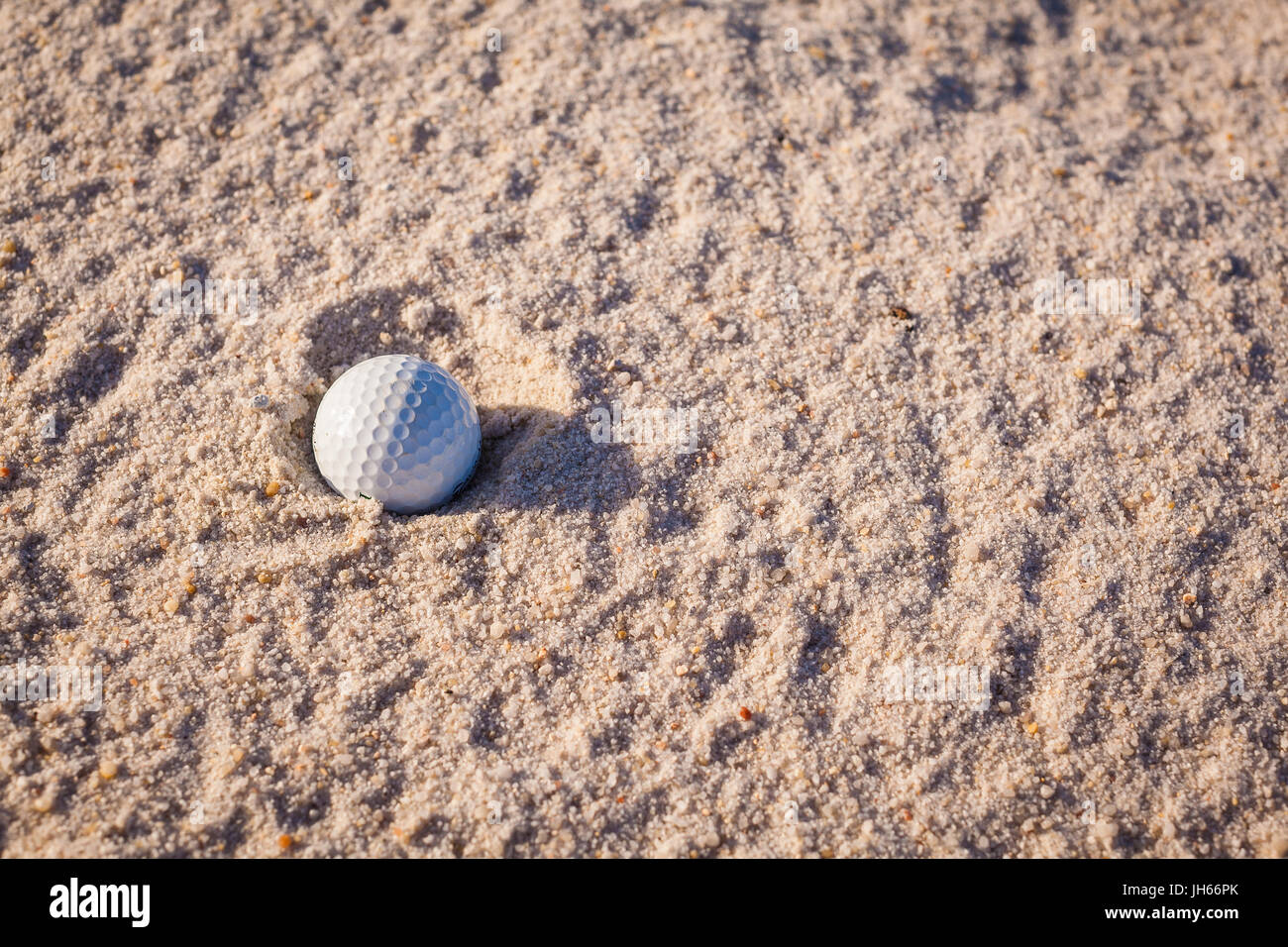 Golf ball in the sand of a bunker on golf course on a sunny day Stock ...