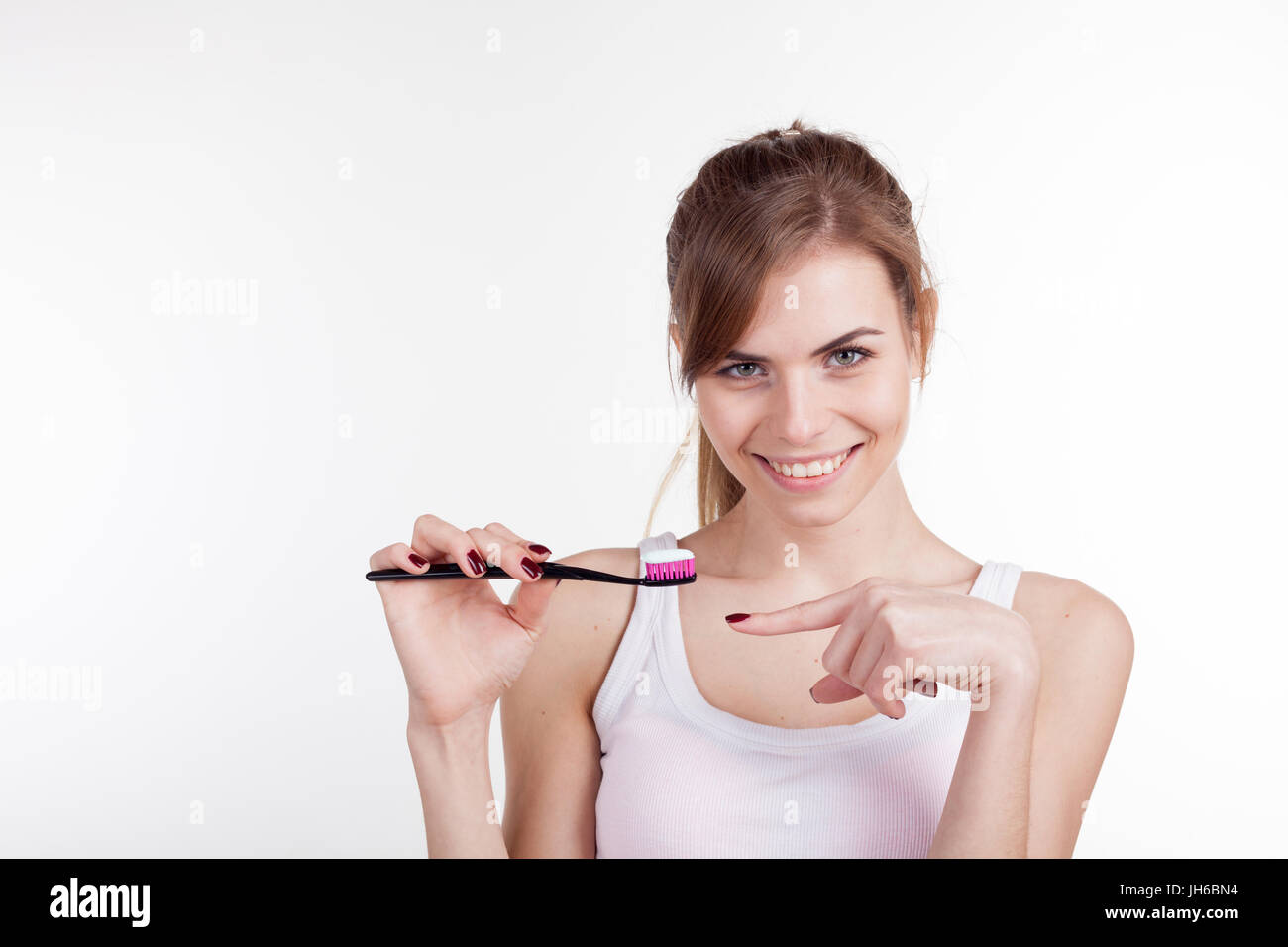 girl shows the finger on the toothbrush smile teeth Stock Photo - Alamy