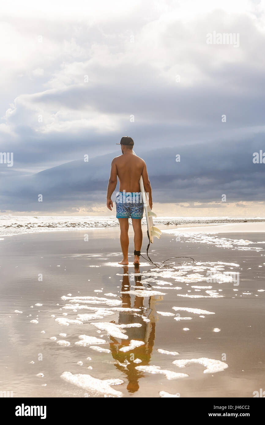 Handsome man stand with surfing board at surf spot at sea ocean beach ...