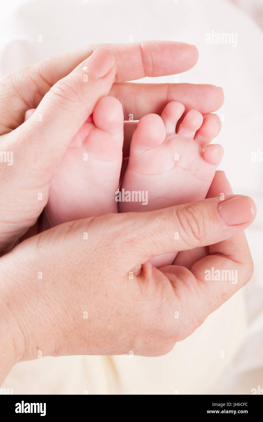 mom's hands hold the feet toes Stock Photo - Alamy