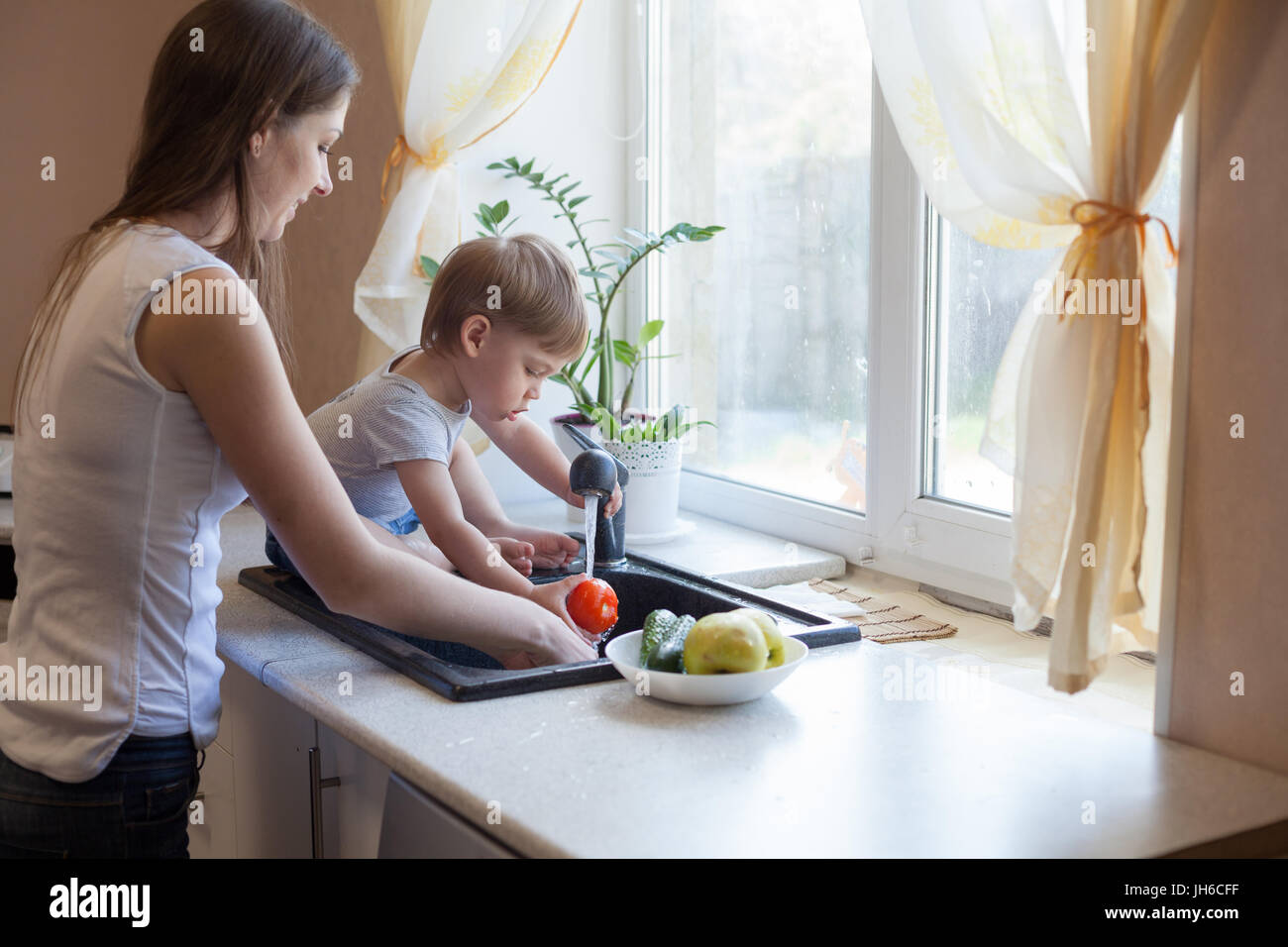 kitchen mom son wash fruits and vegetables Stock Photo - Alamy