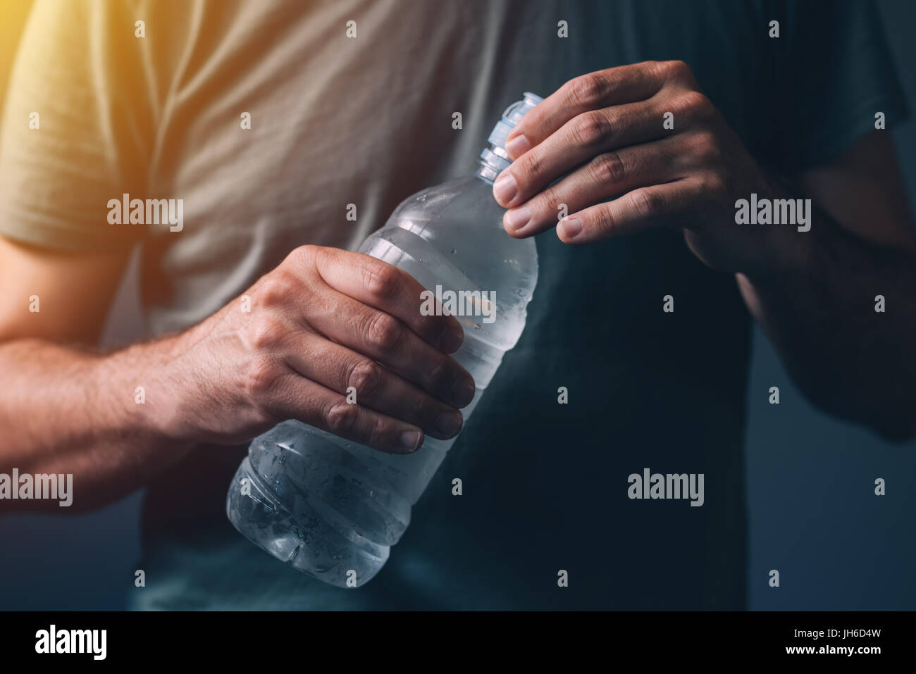 Man with bottle of fresh drinking water for refreshment and ...