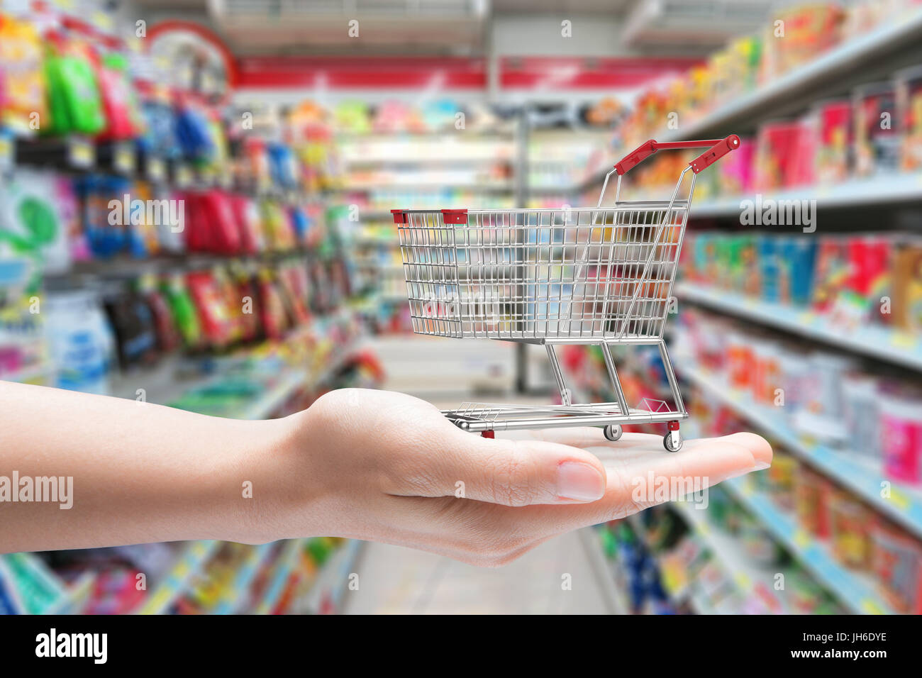 hand holding shopping cart with supermarket background Stock Photo - Alamy