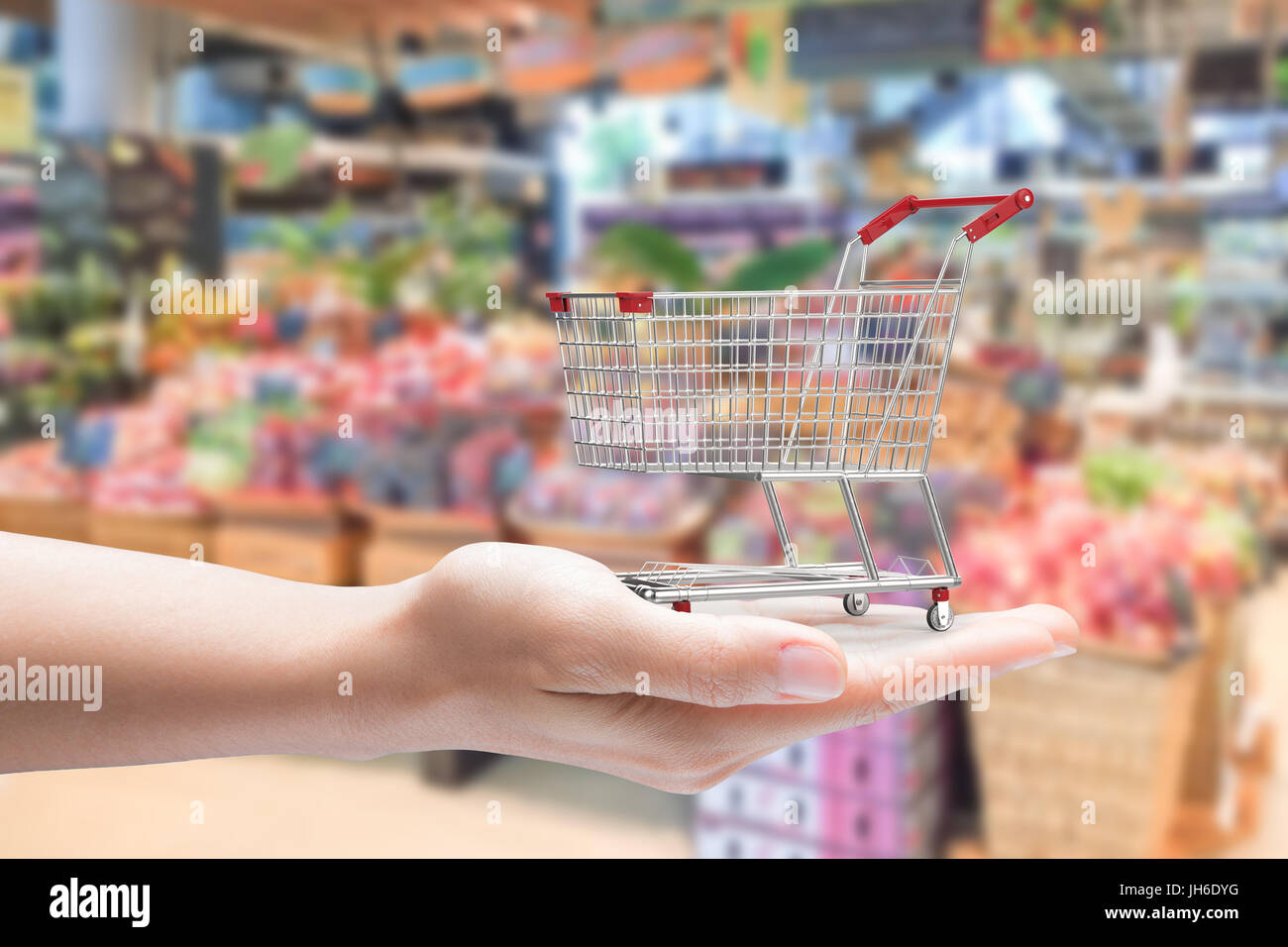 hand holding shopping cart with supermarket background Stock Photo - Alamy