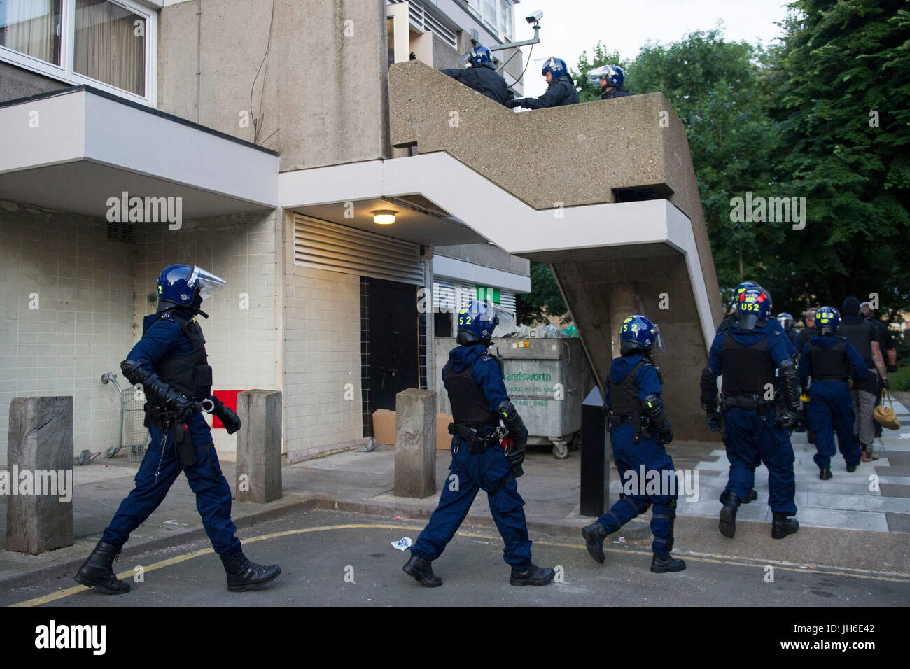 Embargoed to 0001 Friday July 14 Police officers enter a block of flats ...