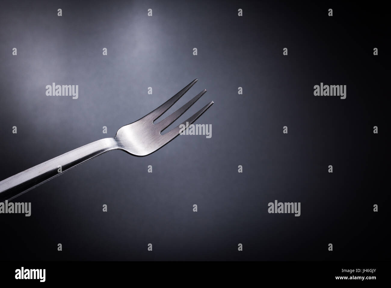Fork in black background Stock Photo - Alamy