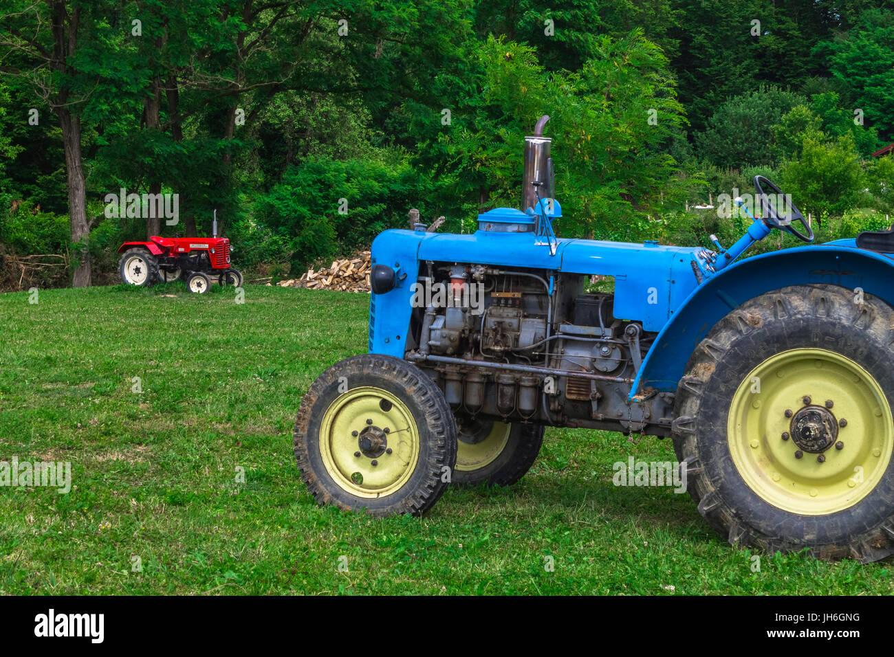 Red and blue tractor in the field Stock Photo - Alamy
