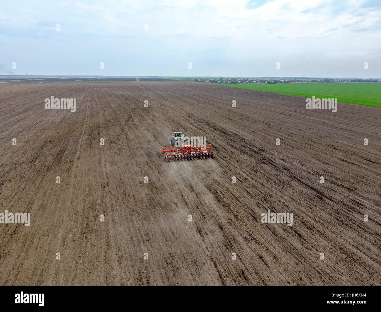 Sowing of corn. Tractor with a seeder on the field. Using a seeder for ...