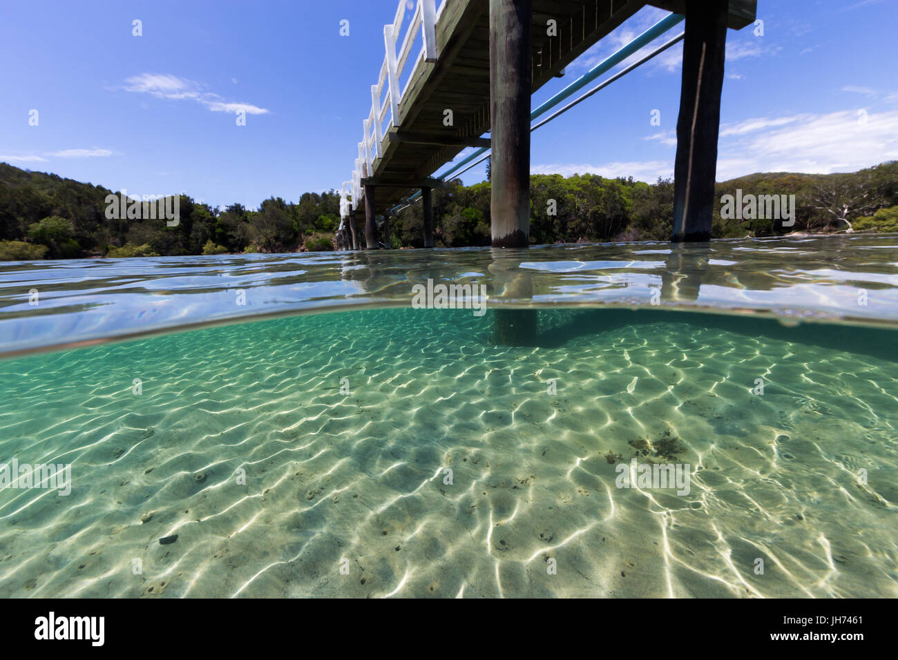 A bridge crosses over beautiful pristine water on a summer day in this ...