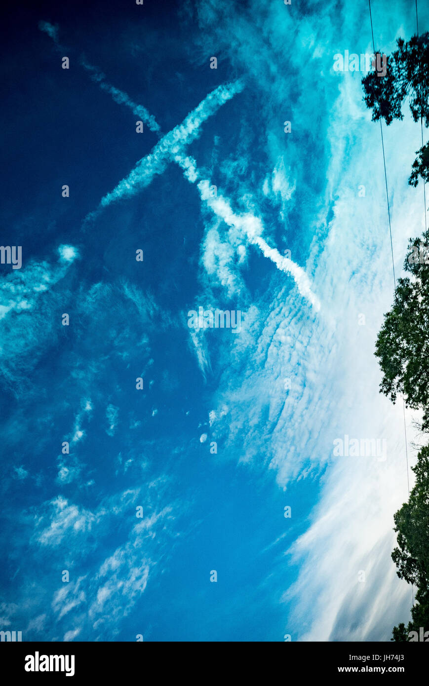 two contrails cross in the evening sky creating a dramatic "cross Stock ...