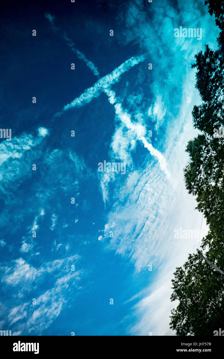 two contrails cross in the evening sky creating a dramatic "cross Stock ...