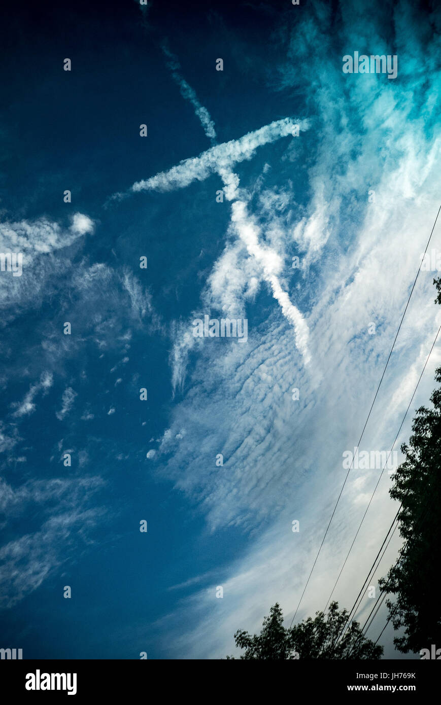 two contrails cross in the evening sky creating a dramatic "cross Stock ...