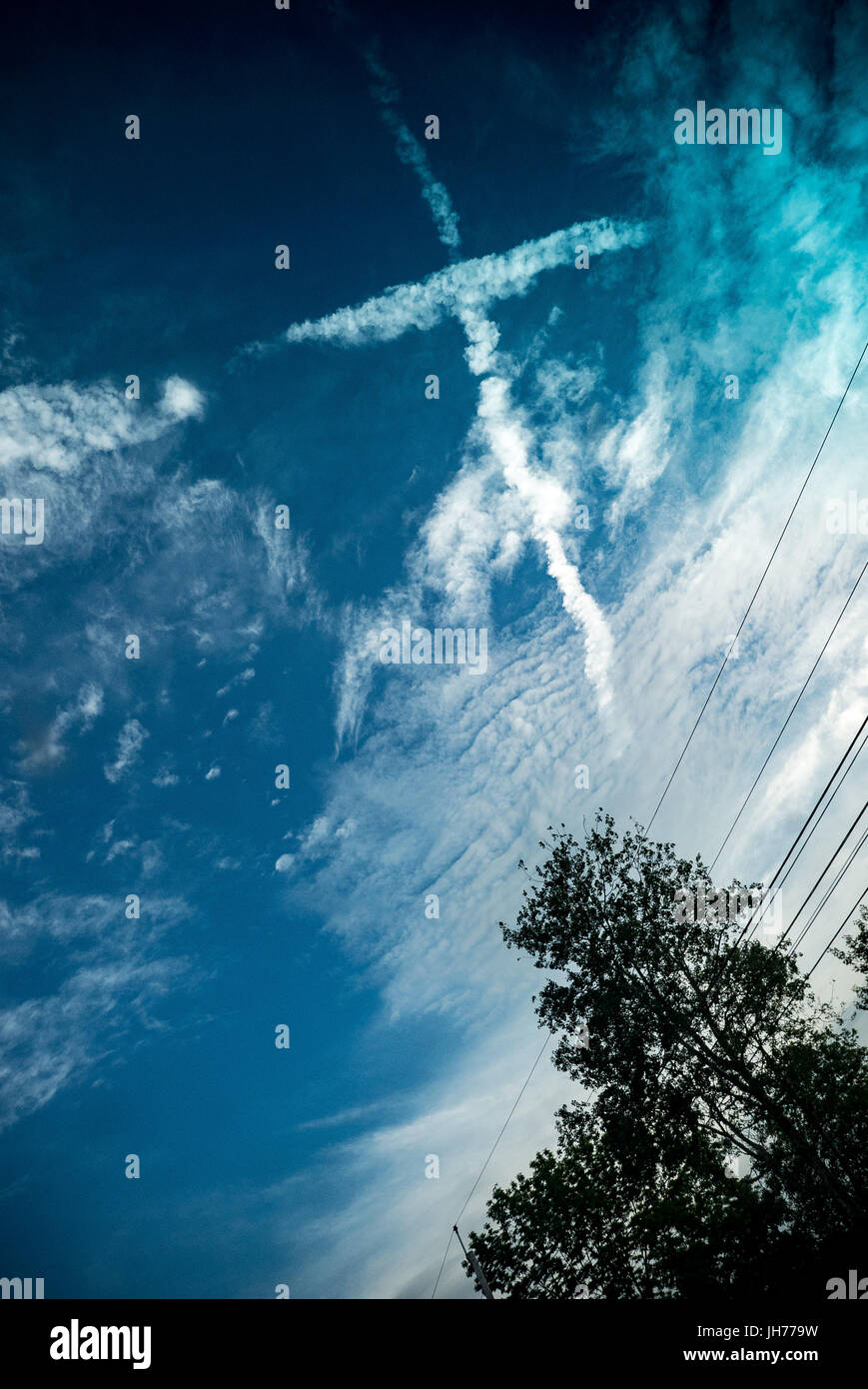 two contrails cross in the evening sky creating a dramatic "cross Stock ...