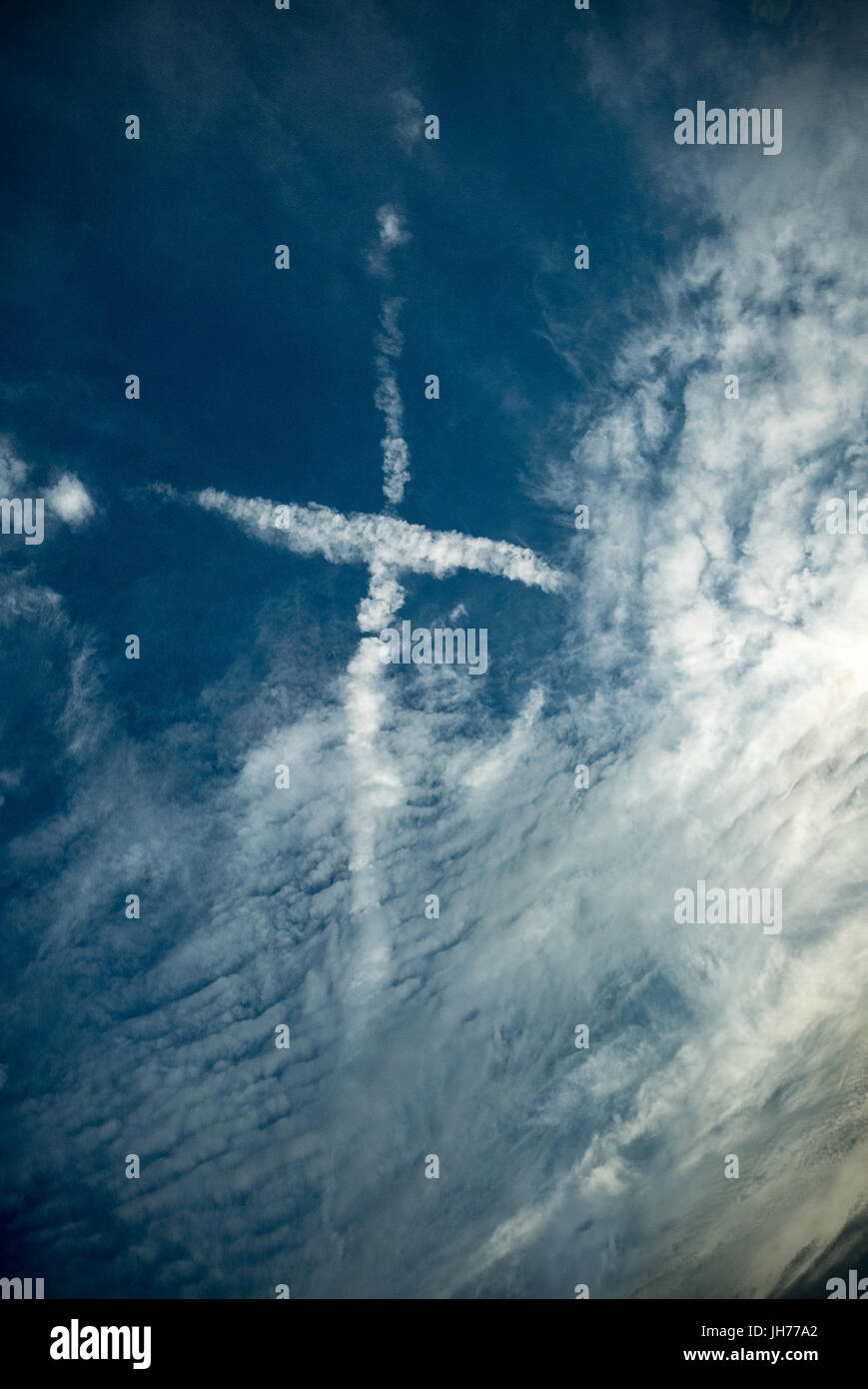 two contrails cross in the evening sky creating a dramatic "cross Stock ...