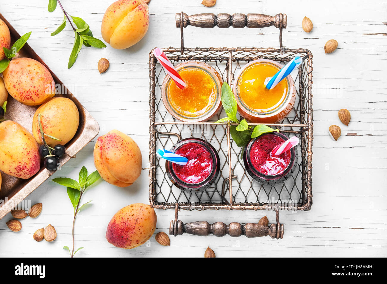 Jars with apricot and berry smoothies in stylish metal basket.Smoothie ...