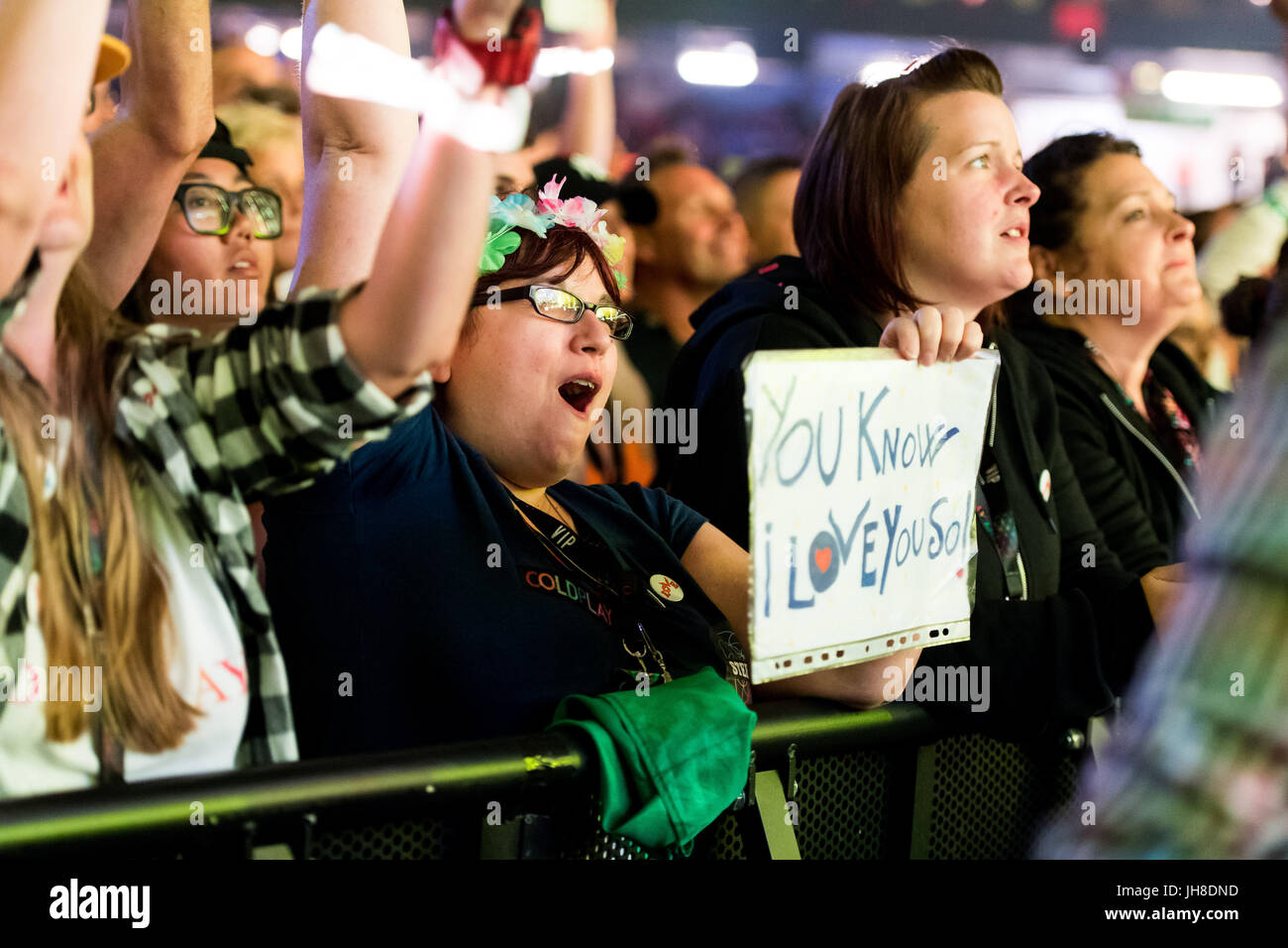 Fans in the crowd watch Coldplay perform at the Principality Stadium ...
