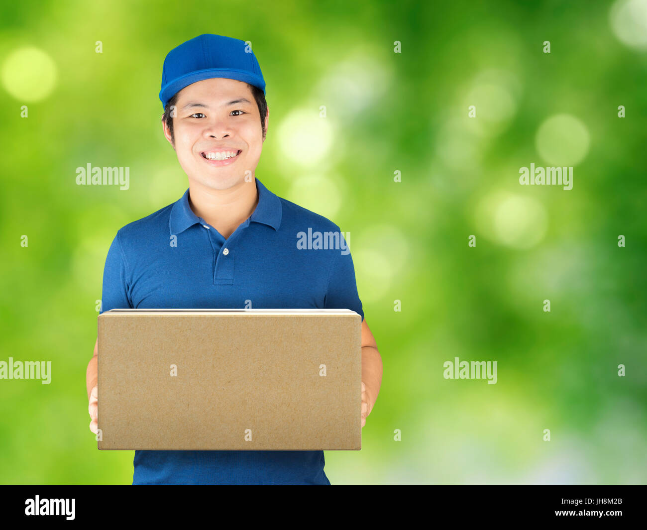 asian delivery man holding carton box Stock Photo - Alamy