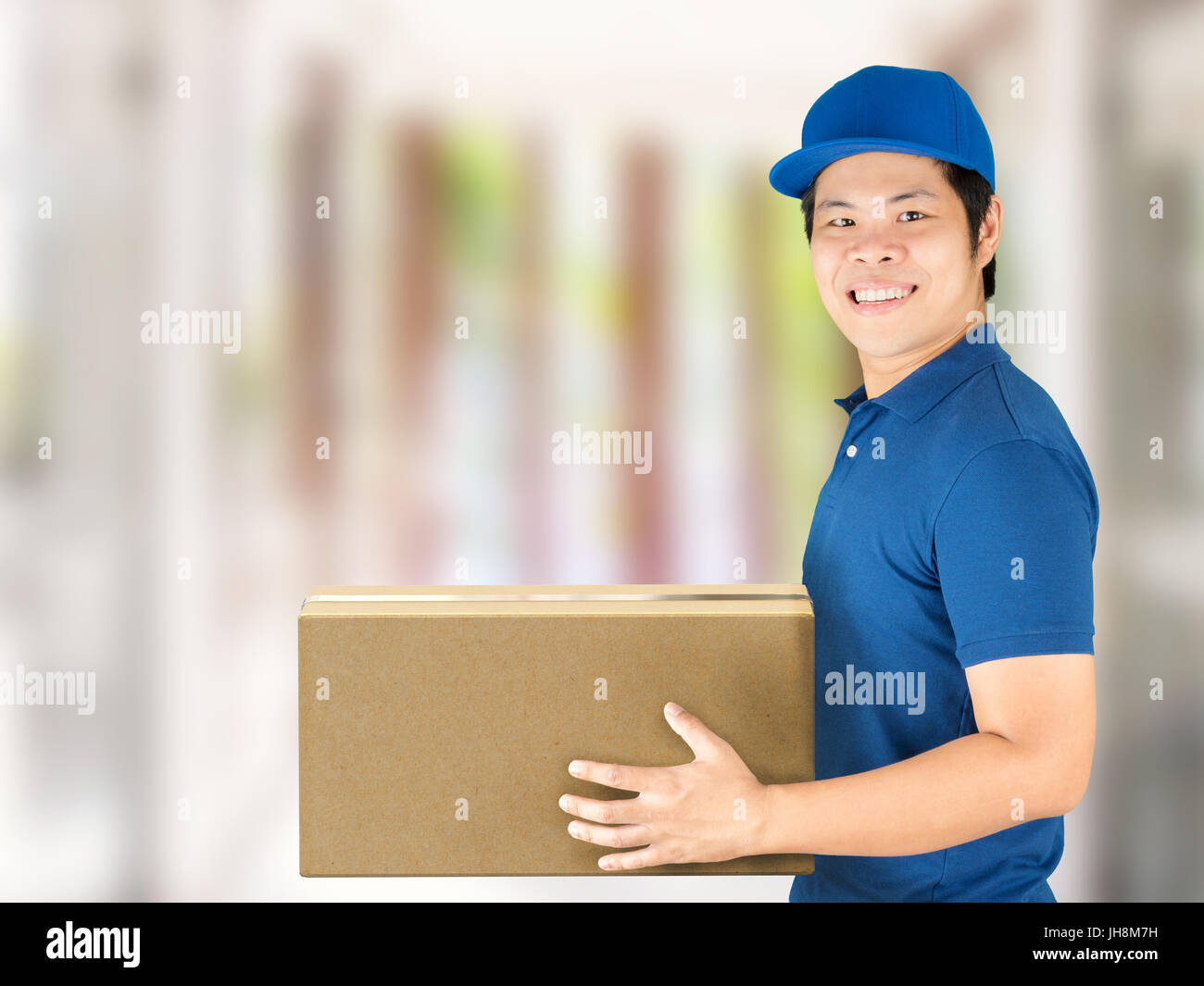 asian delivery man holding carton box Stock Photo - Alamy