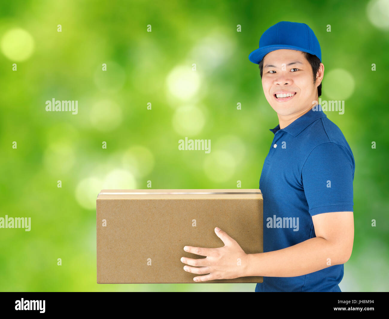 asian delivery man holding carton box Stock Photo - Alamy