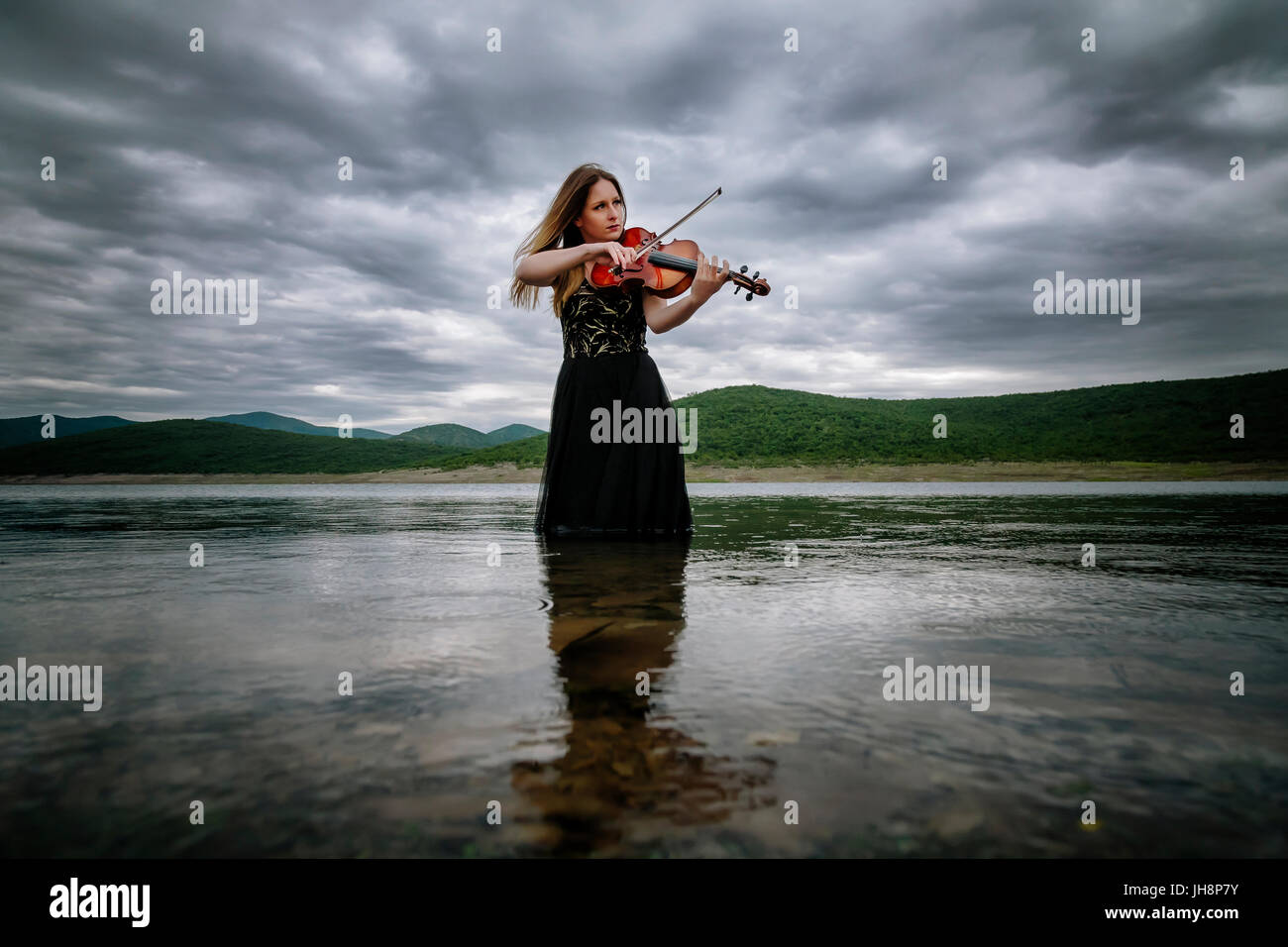 Beautiful female viola player on the lake shore Stock Photo - Alamy