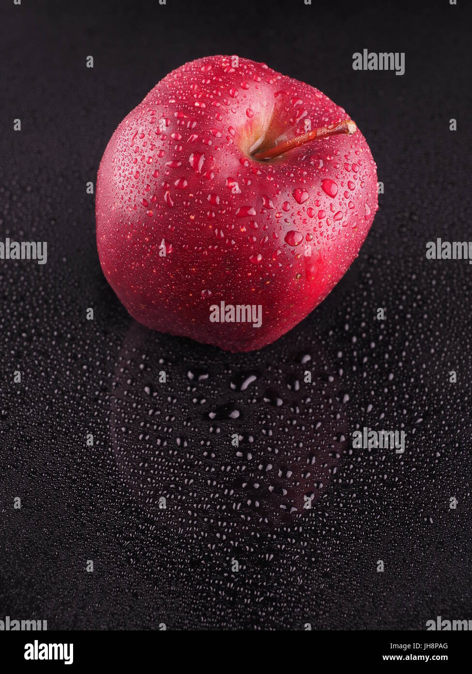 Red apple on a dark background with droplets Stock Photo - Alamy