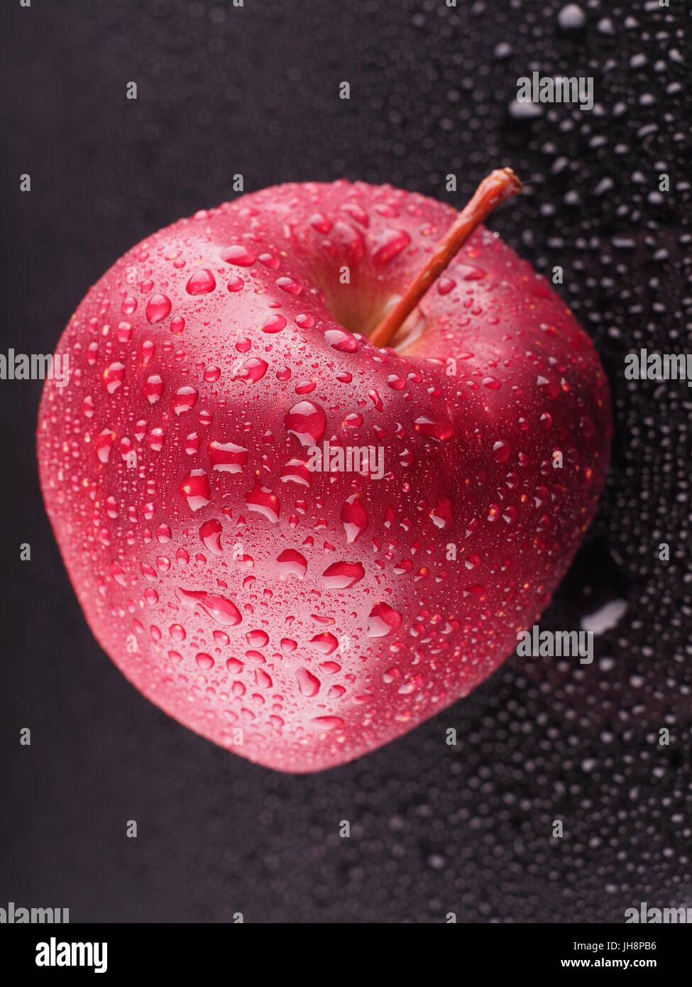 Red apple on a dark background with droplets Stock Photo - Alamy