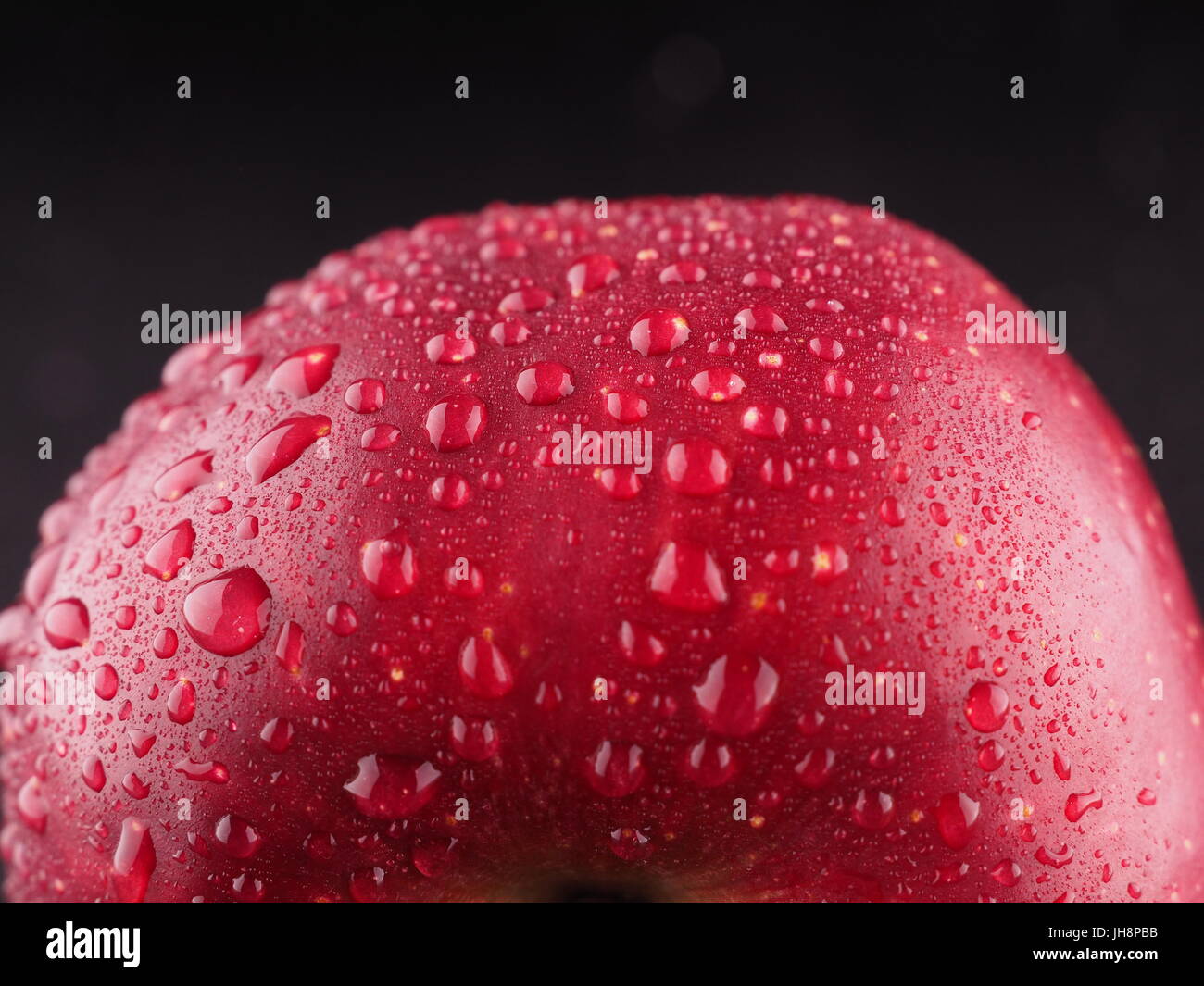 Red apple on a dark background with droplets Stock Photo - Alamy