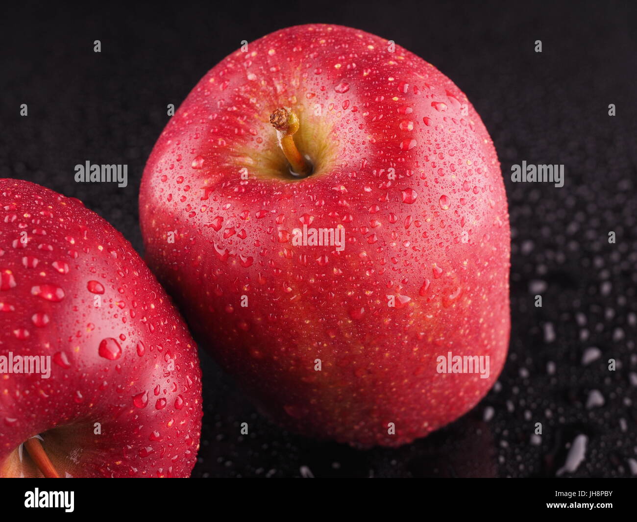 Red apple on a dark background with droplets Stock Photo - Alamy