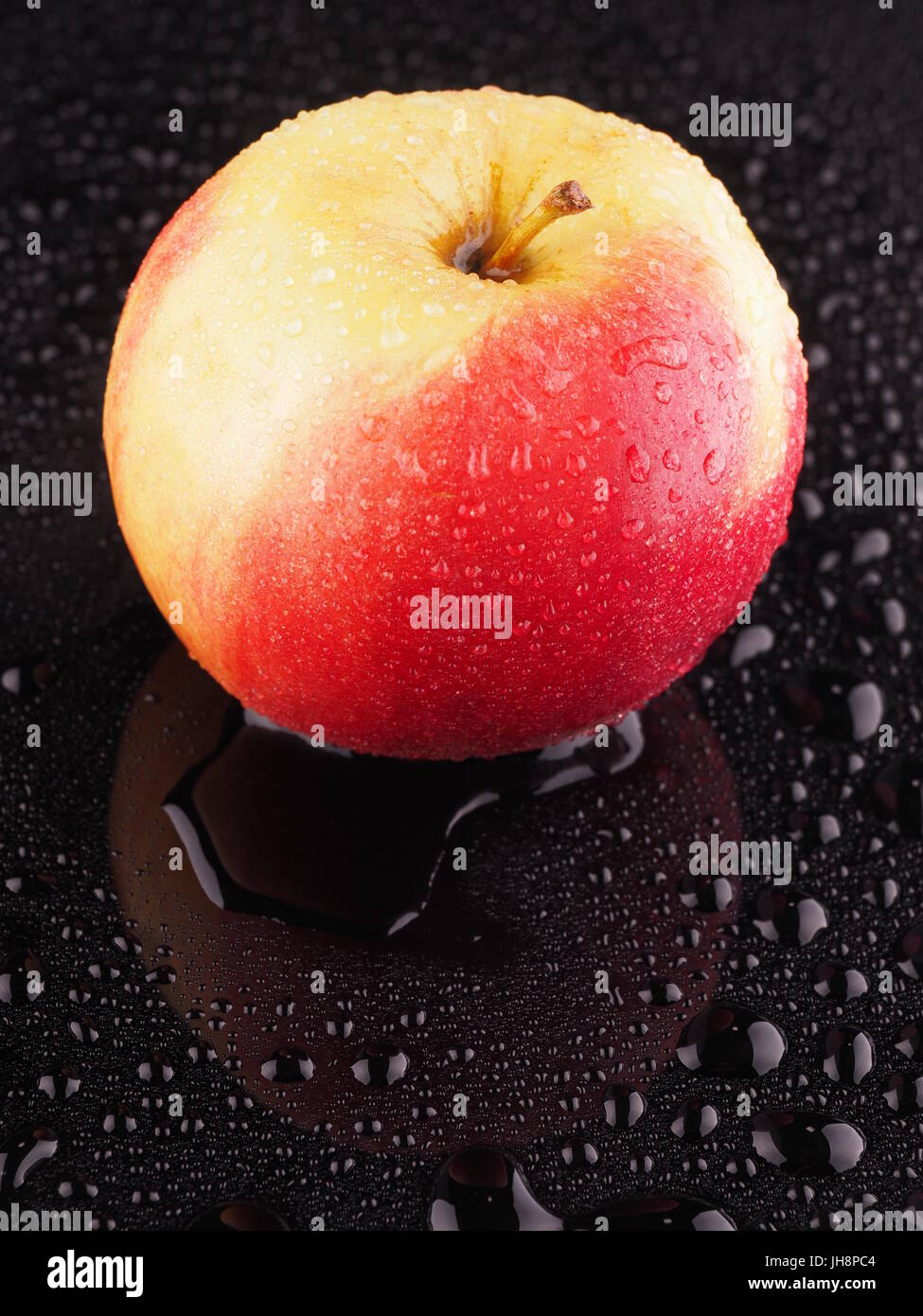 Red apple on a dark background with droplets Stock Photo - Alamy