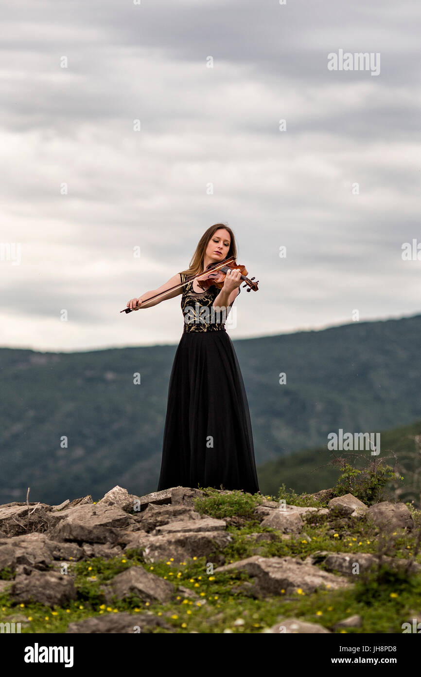 Beautiful female viola player on the lake shore Stock Photo - Alamy