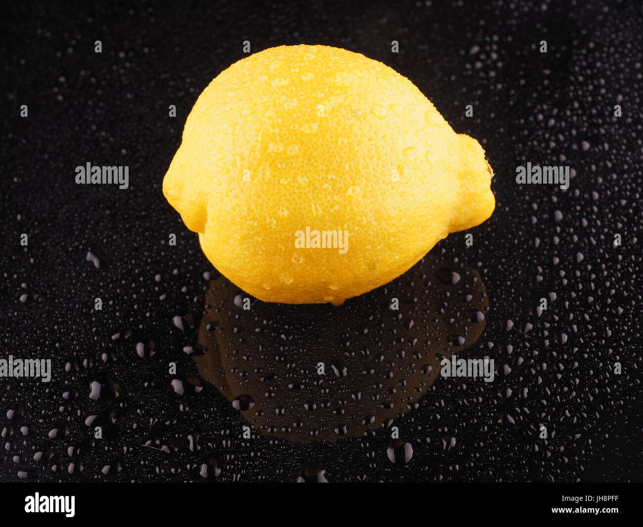 Lemon on a dark background with droplets Stock Photo - Alamy