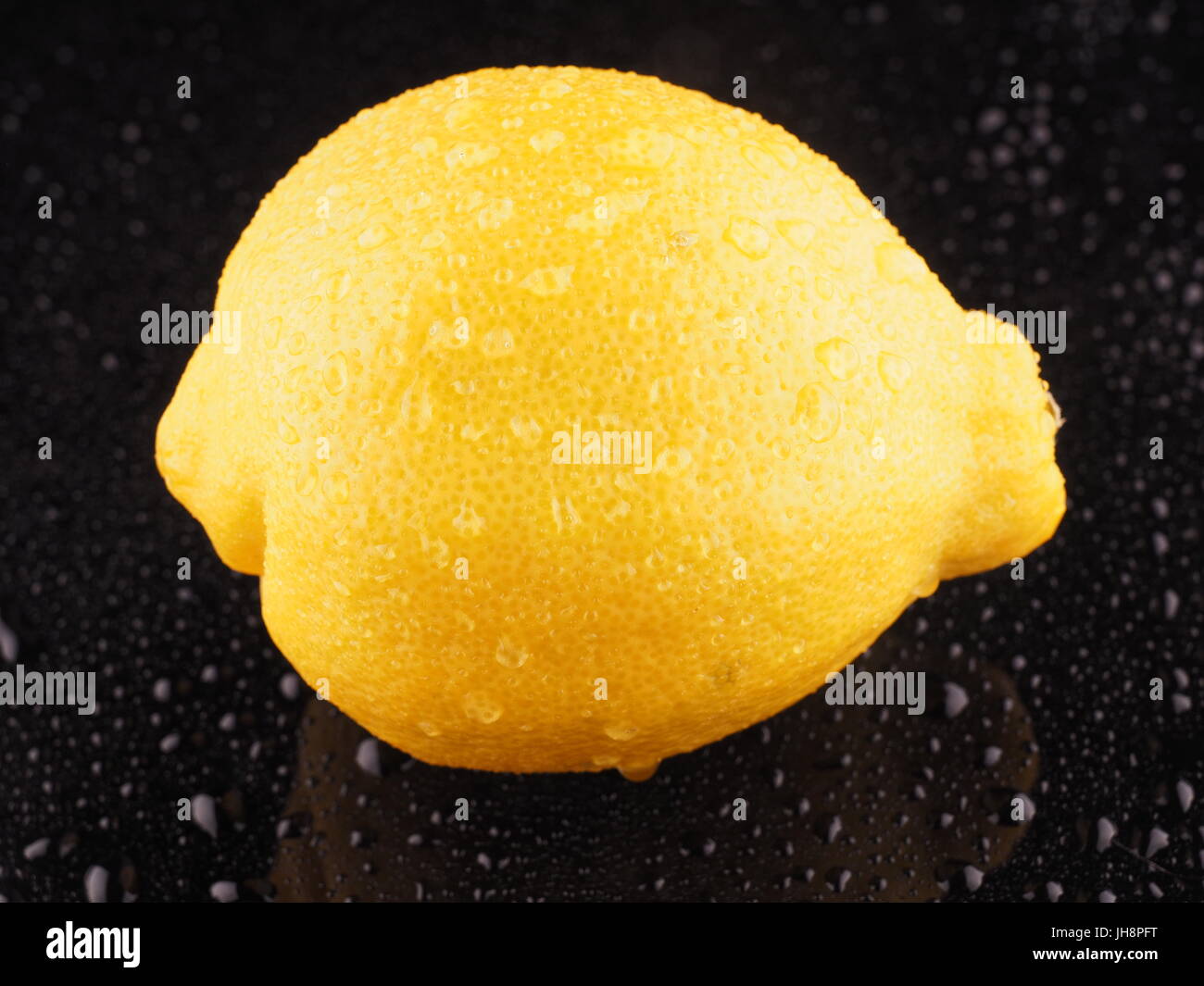 Lemon on a dark background with droplets Stock Photo - Alamy