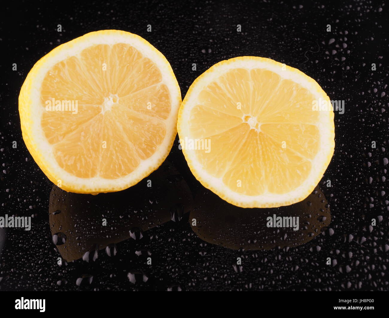 Lemon on a dark background with droplets Stock Photo - Alamy