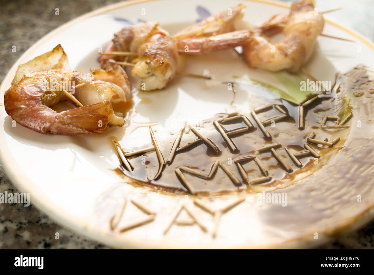 happy mother day written with toothpicks in a dish of roasted prawns ...