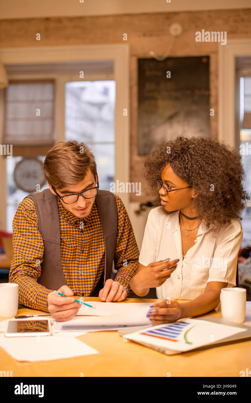 Two business partners, one of which is african american girl sitting by ...