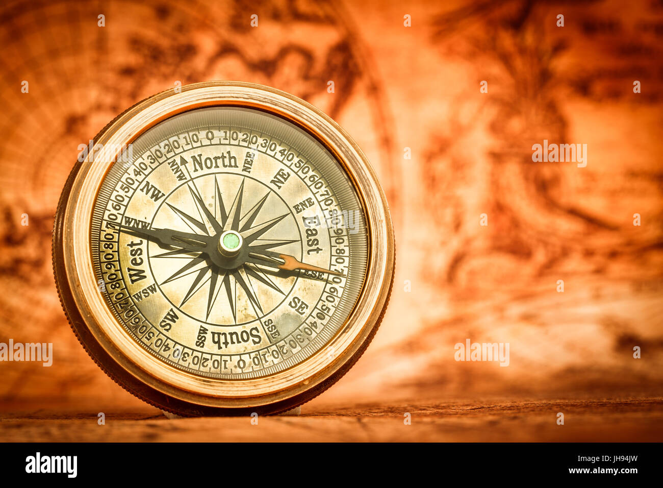 Vintage still life. Vintage compass lies on an ancient world map in ...