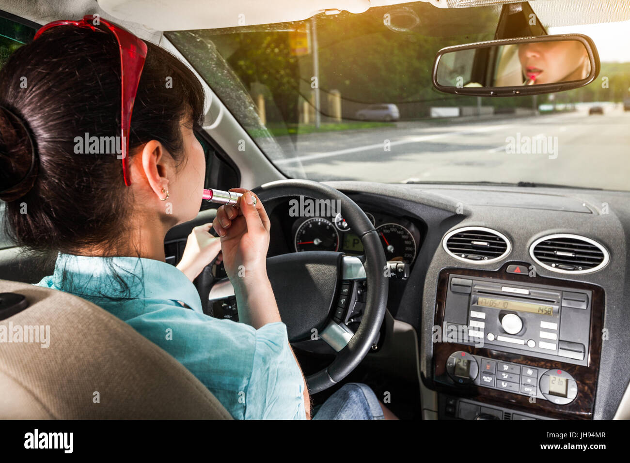 Women make up lips at the wheel the car Stock Photo - Alamy