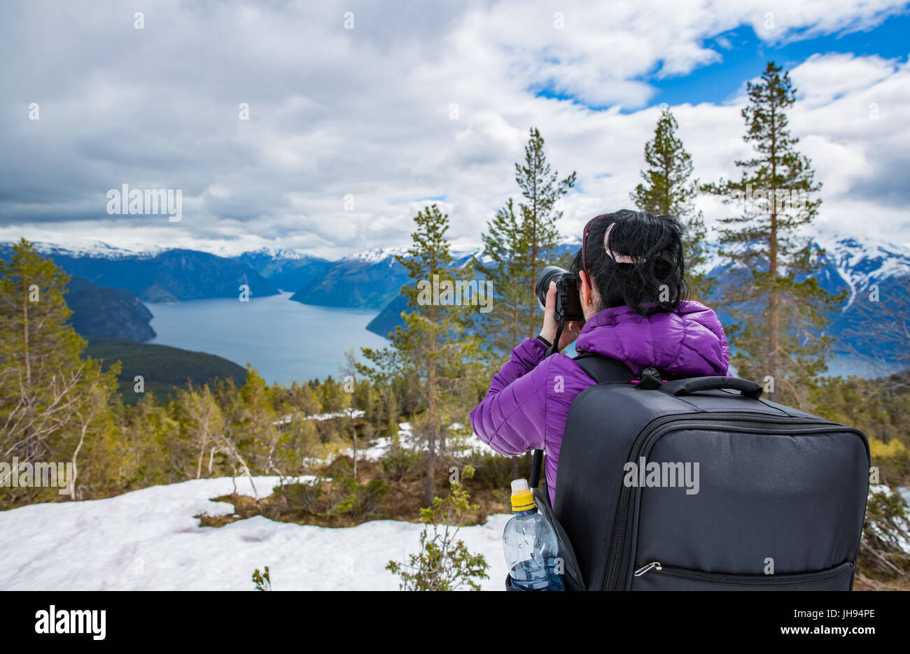 Nature photographer tourist with camera shoots while standing on top of ...