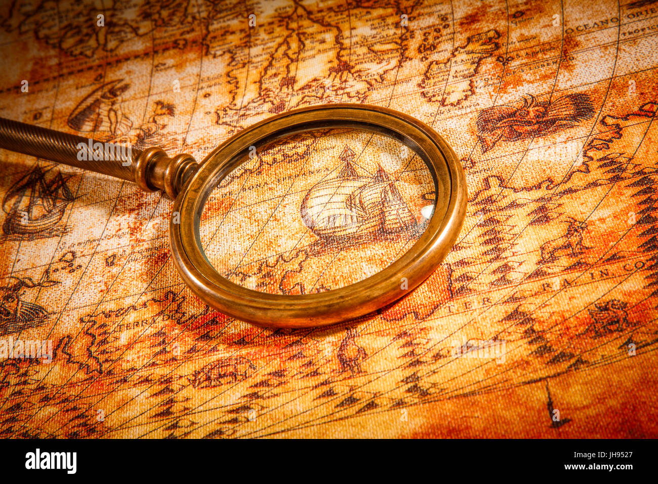Vintage still life. Vintage magnifying glass lies on an ancient world ...