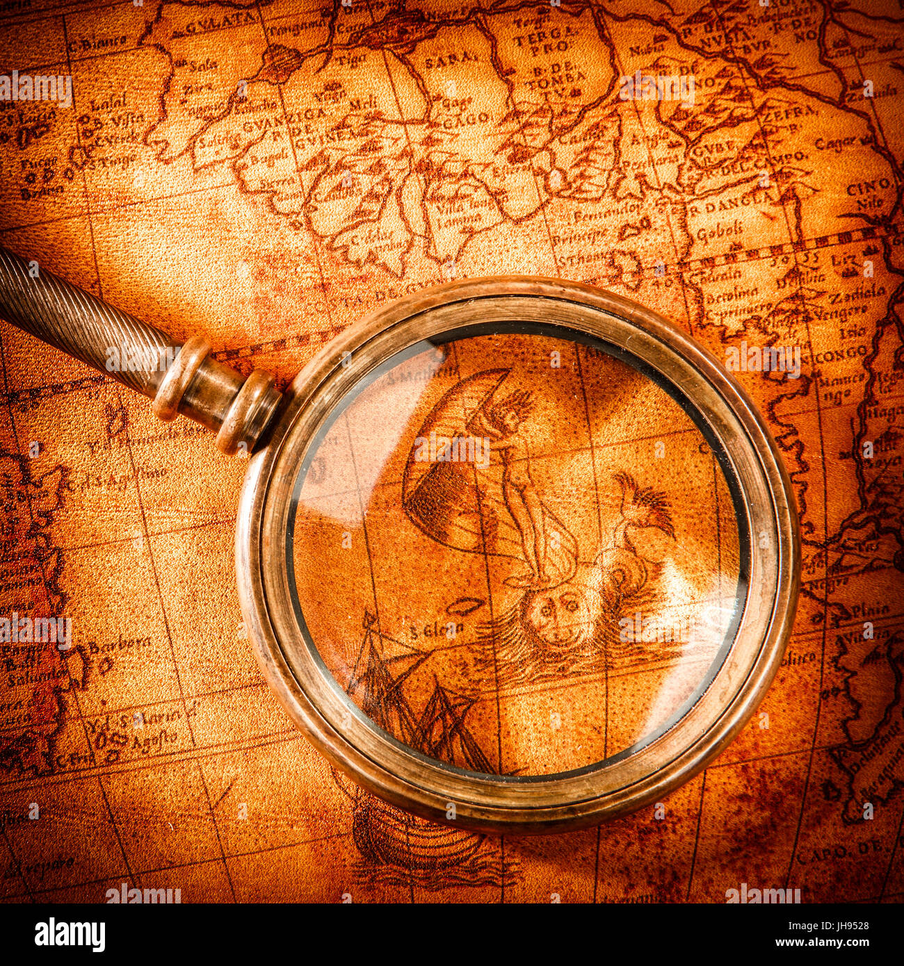 Vintage still life. Vintage magnifying glass lies on an ancient world ...