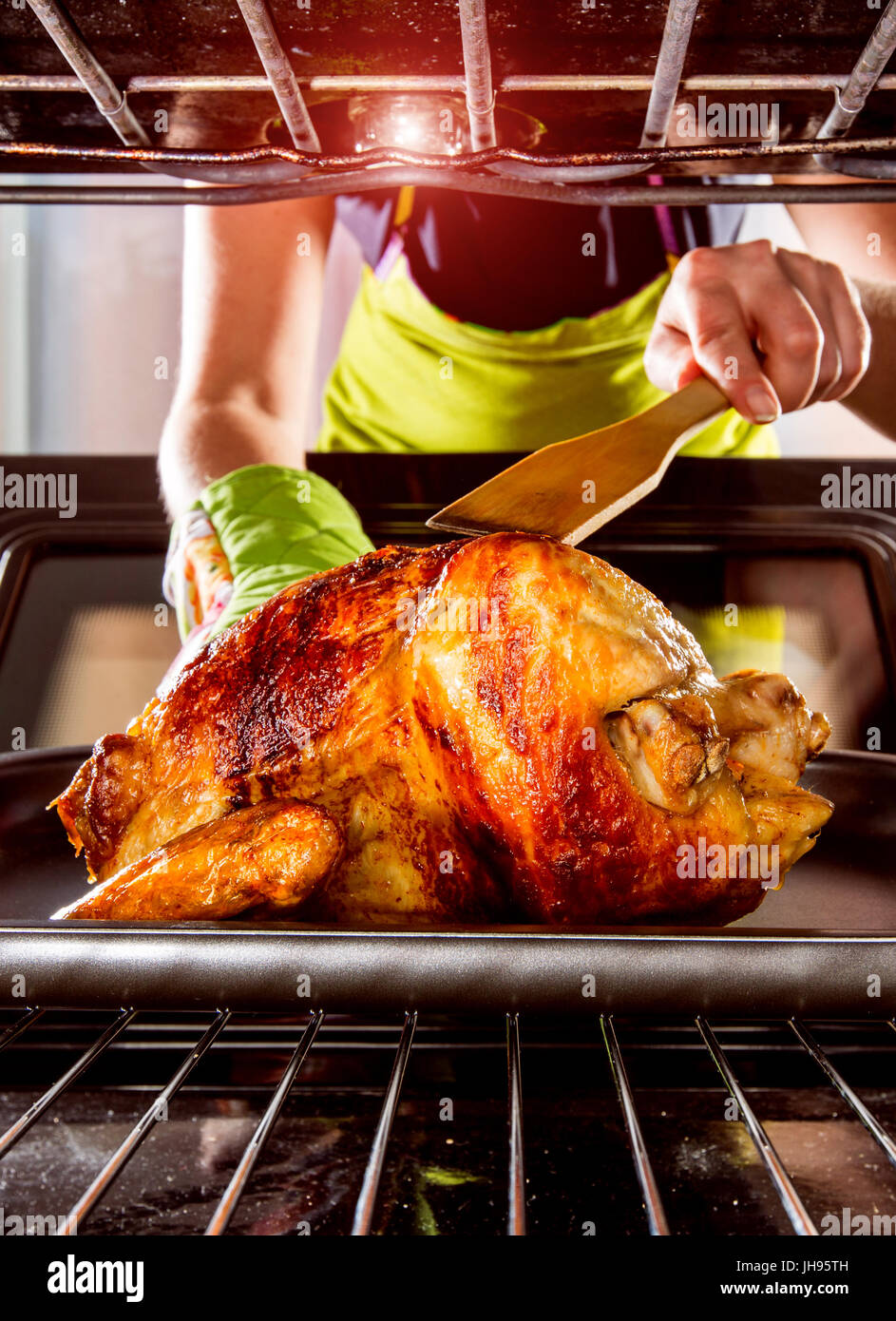 Housewife prepares roast chicken in the oven, view from the inside of ...