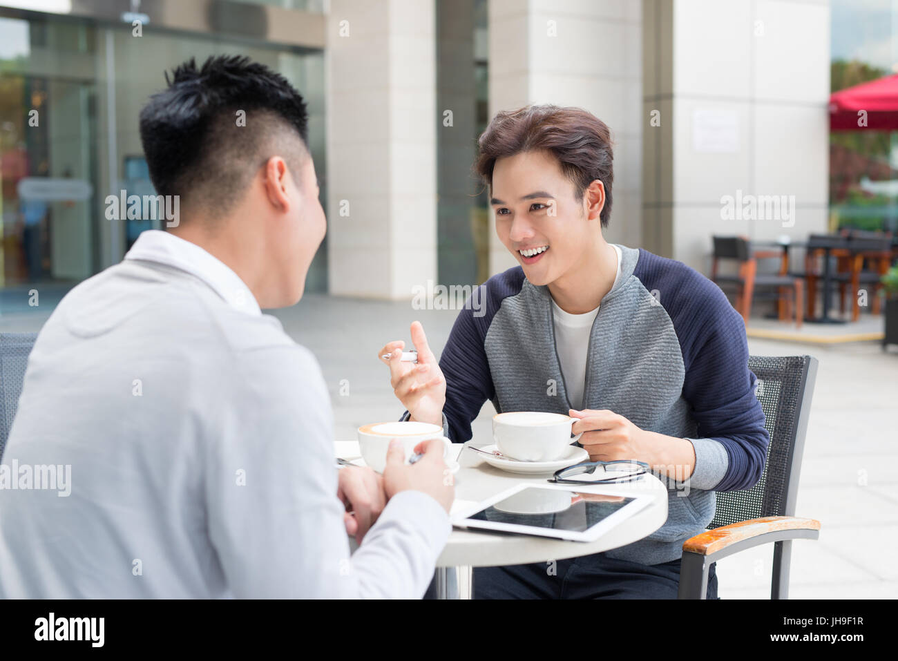 Two young men sitting cafe friends hi-res stock photography and images ...
