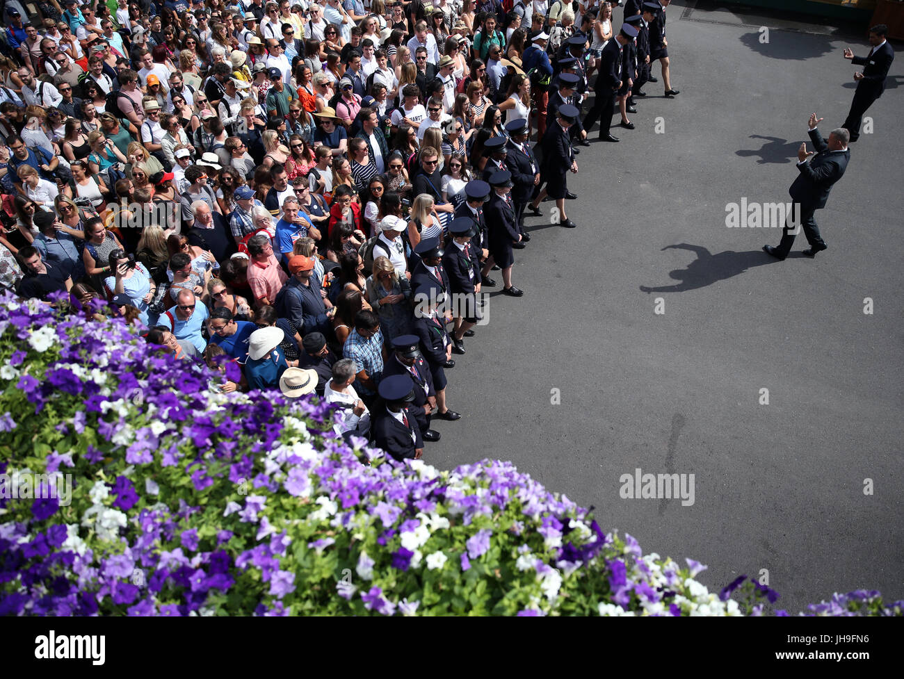 Spectators are led into the grounds on day ten of the Wimbledon ...