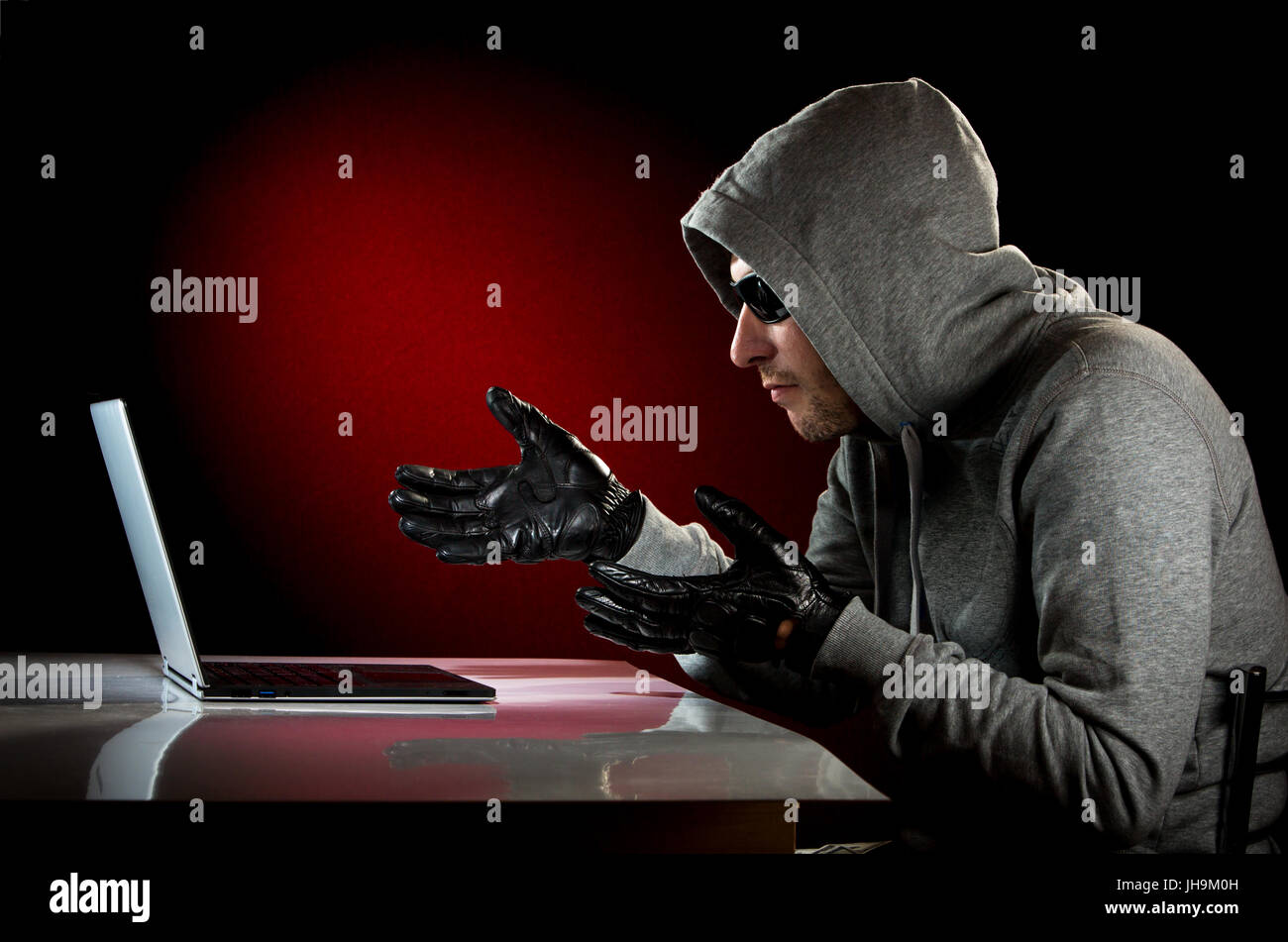 Hacker in a sunglasses with laptop Stock Photo - Alamy