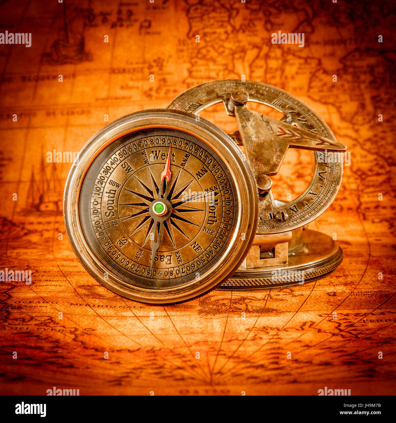 Vintage still life. Vintage compass lies on an ancient world map in ...