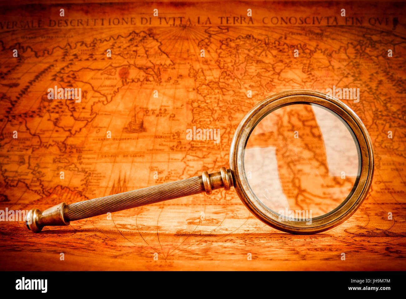Vintage still life. Vintage magnifying glass lies on an ancient world ...